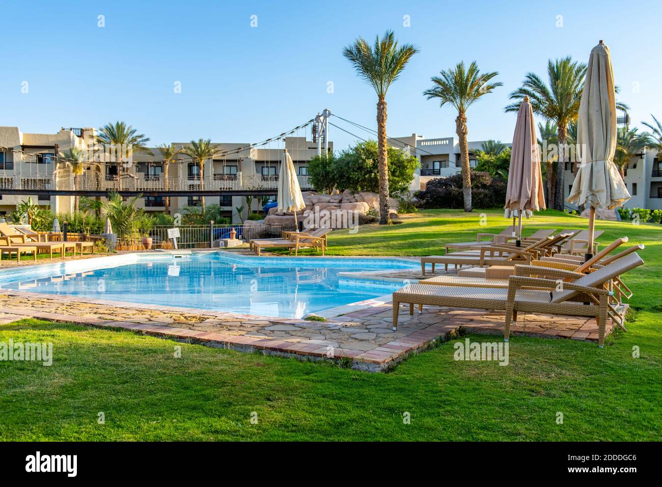 Luxury resort with swimming pool, sun loungers and beach umbrellas ...