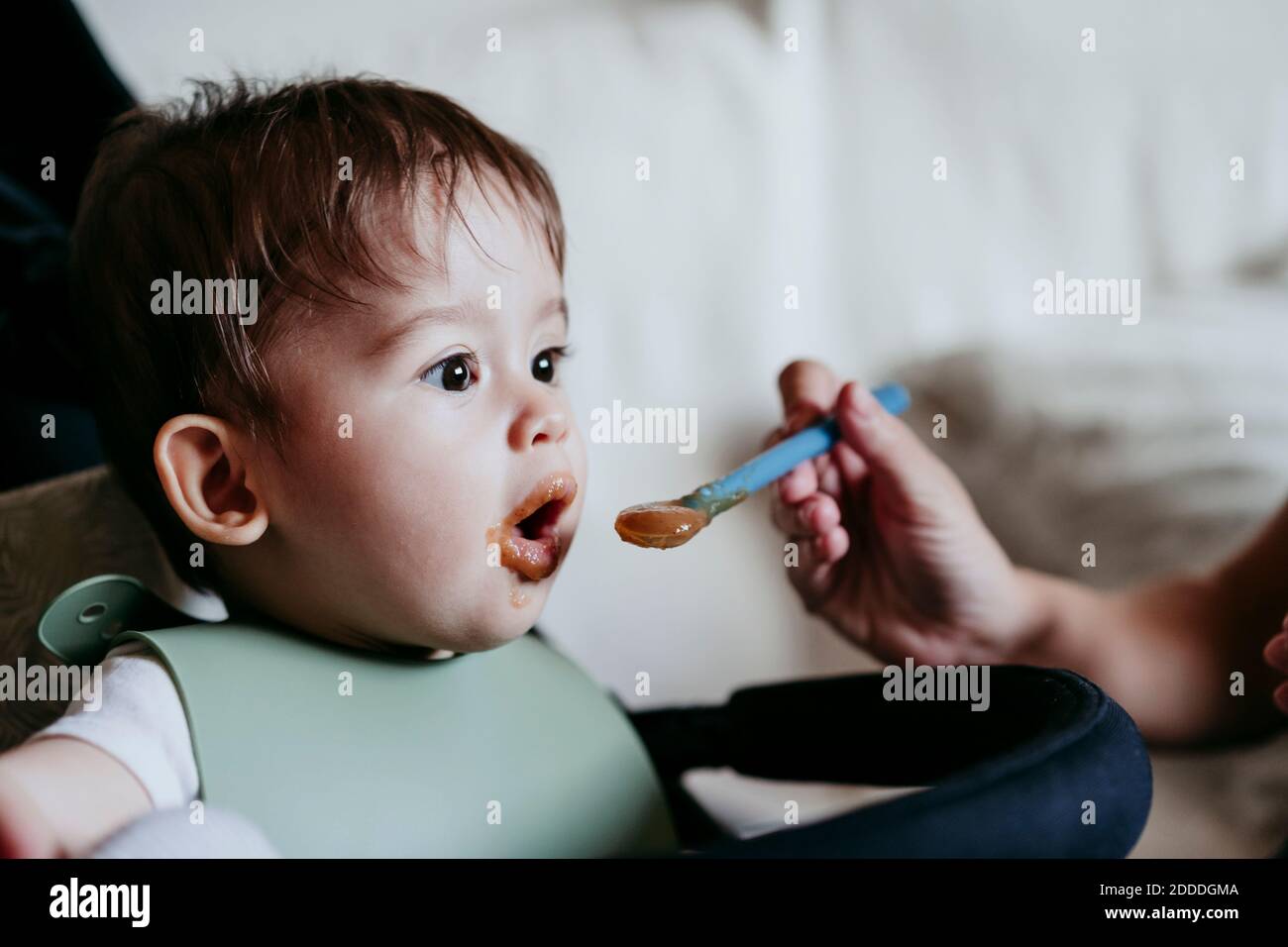 Mother's hand feeding baby boy at home Stock Photo - Alamy