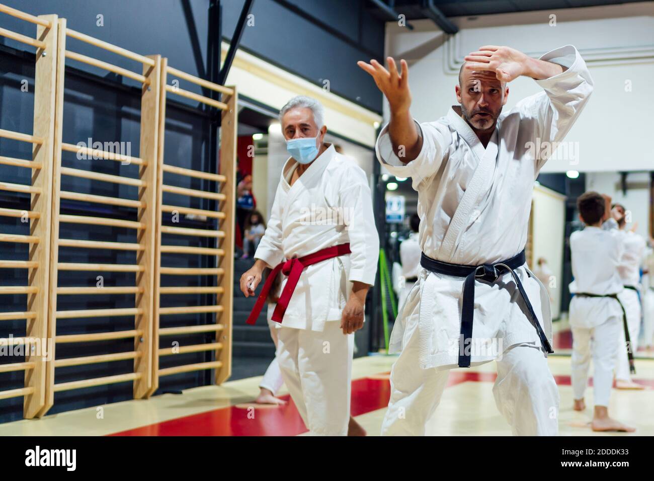 Instructor by male student practicing karate in class Stock Photo - Alamy