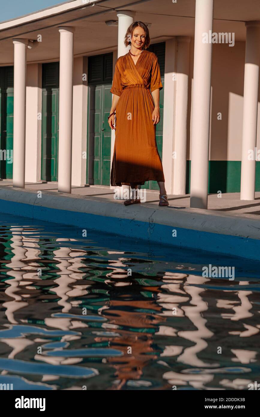 Woman standing in front of swimming pool hi-res stock photography and ...