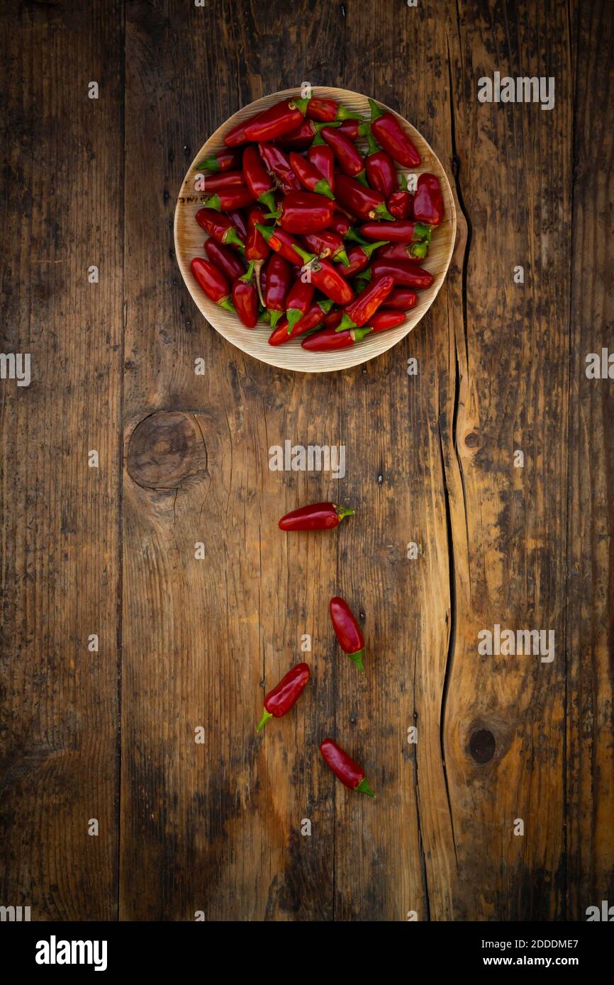 Plate of fresh red chili peppers on wooden surface Stock Photo - Alamy