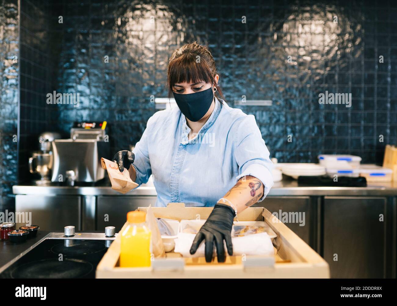 Female chef keeping take out food in cardboard box at restaurant ...