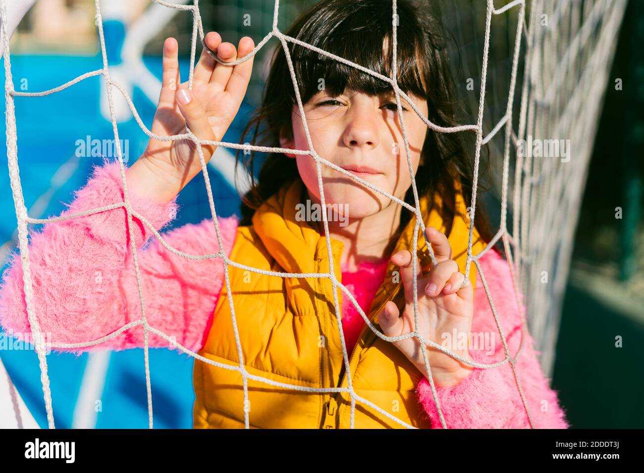 Cute girl seen through net of goal post during sunny day Stock Photo ...