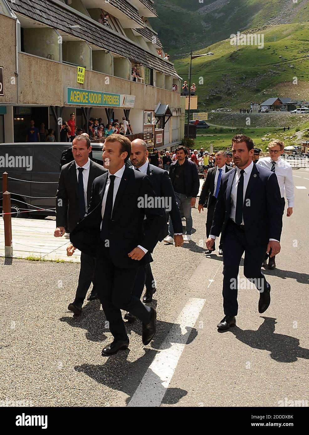 French President Emmanuel Macron greets people as he arrives to visit ...