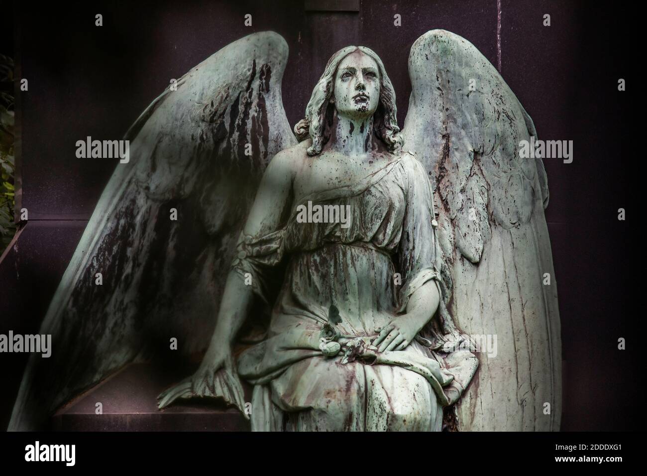 Weathered statue of sitting angel Stock Photo - Alamy