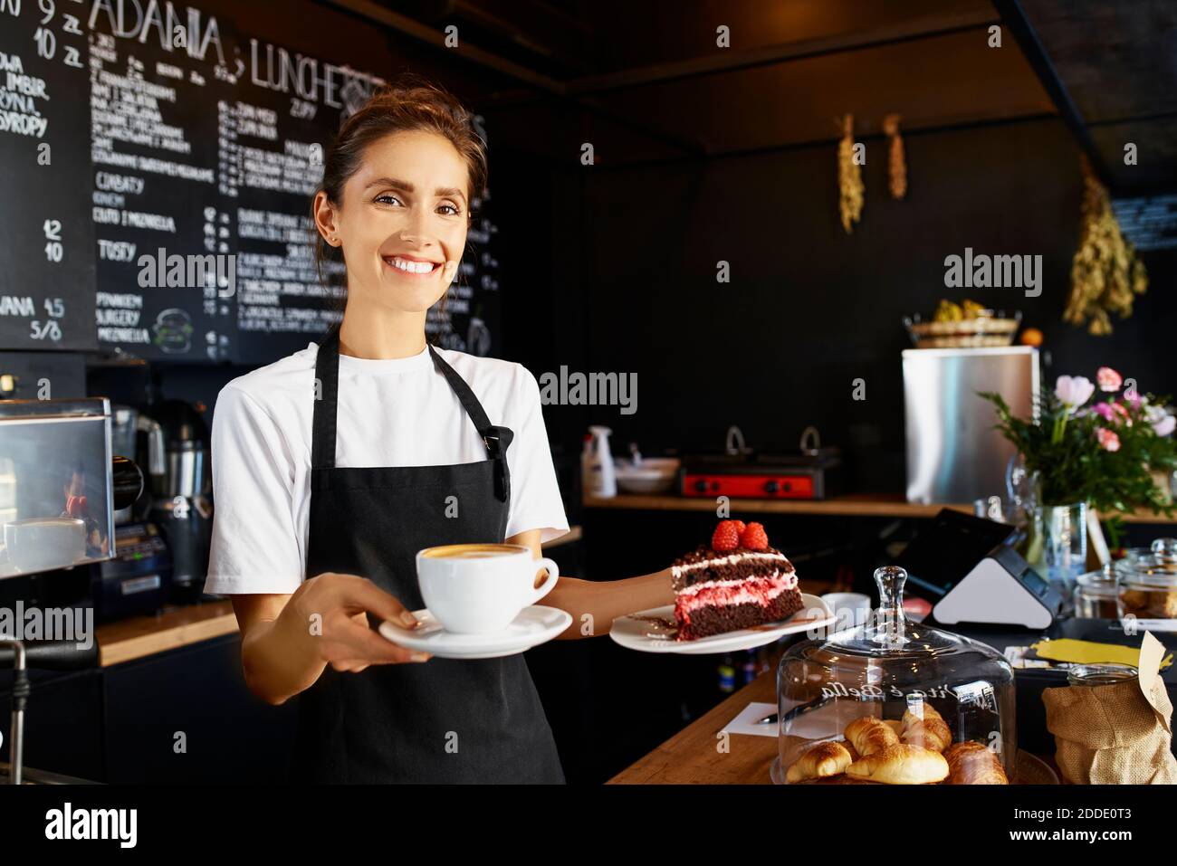 Portrait of smiling waitress giving coffee and pastry at cafe Stock ...