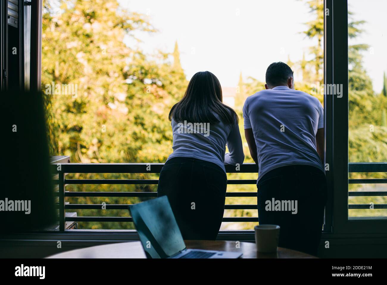 Couple leaning on balcony railing while standing at home Stock Photo ...