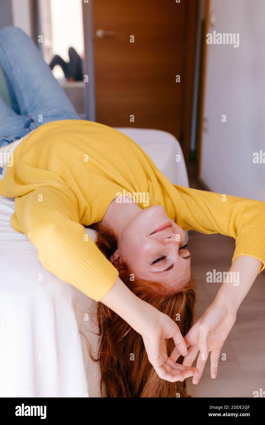 Young woman resting on bed in bedroom at home Stock Photo - Alamy