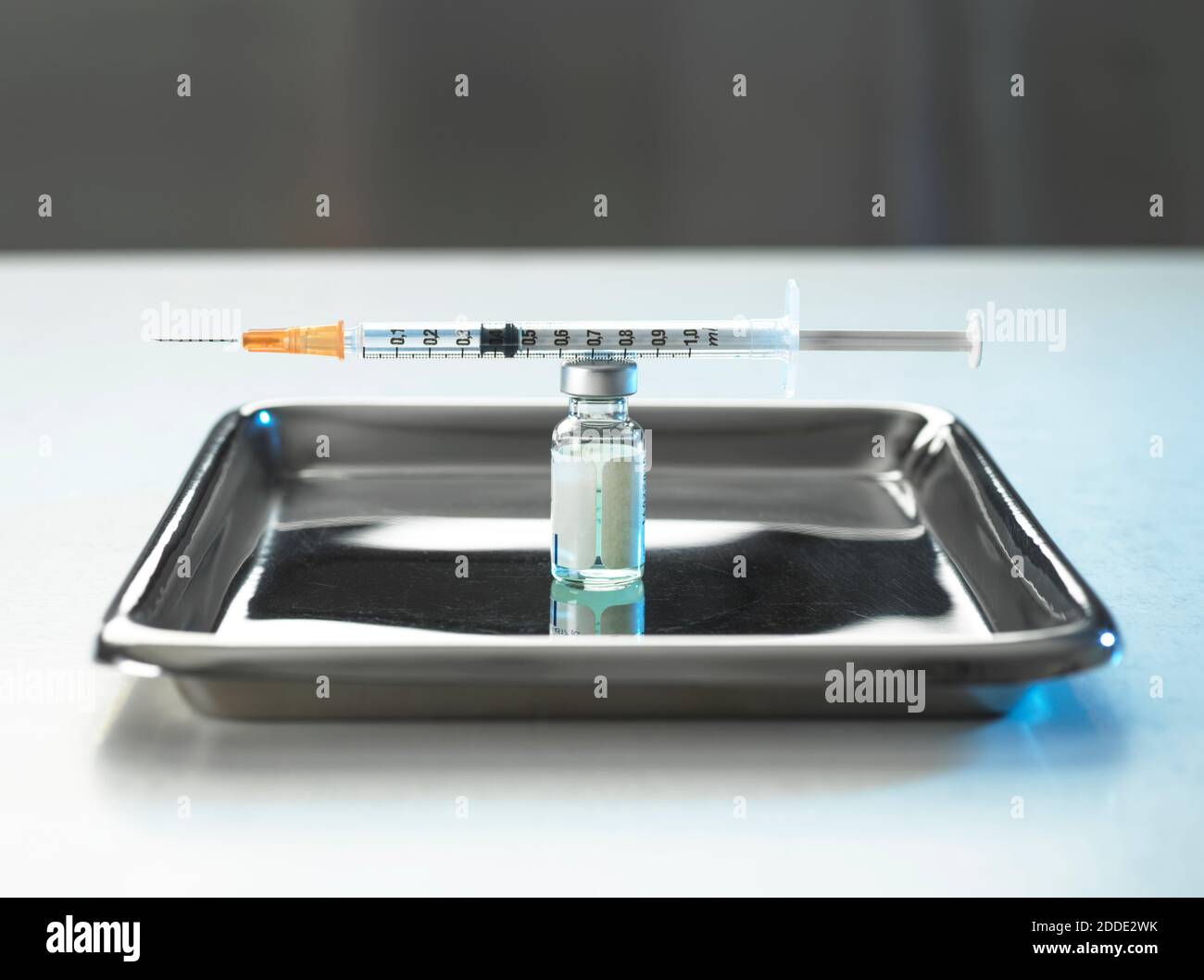 Syringe balancing on top of vaccine vial Stock Photo - Alamy