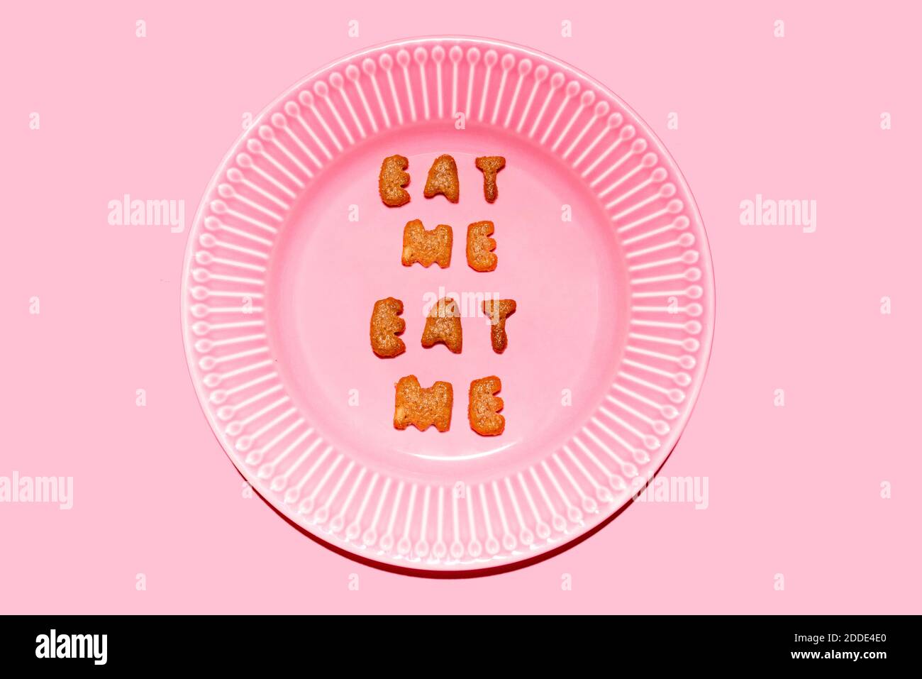 Plate with biscuit letters arranged into message Eat Me Stock Photo - Alamy