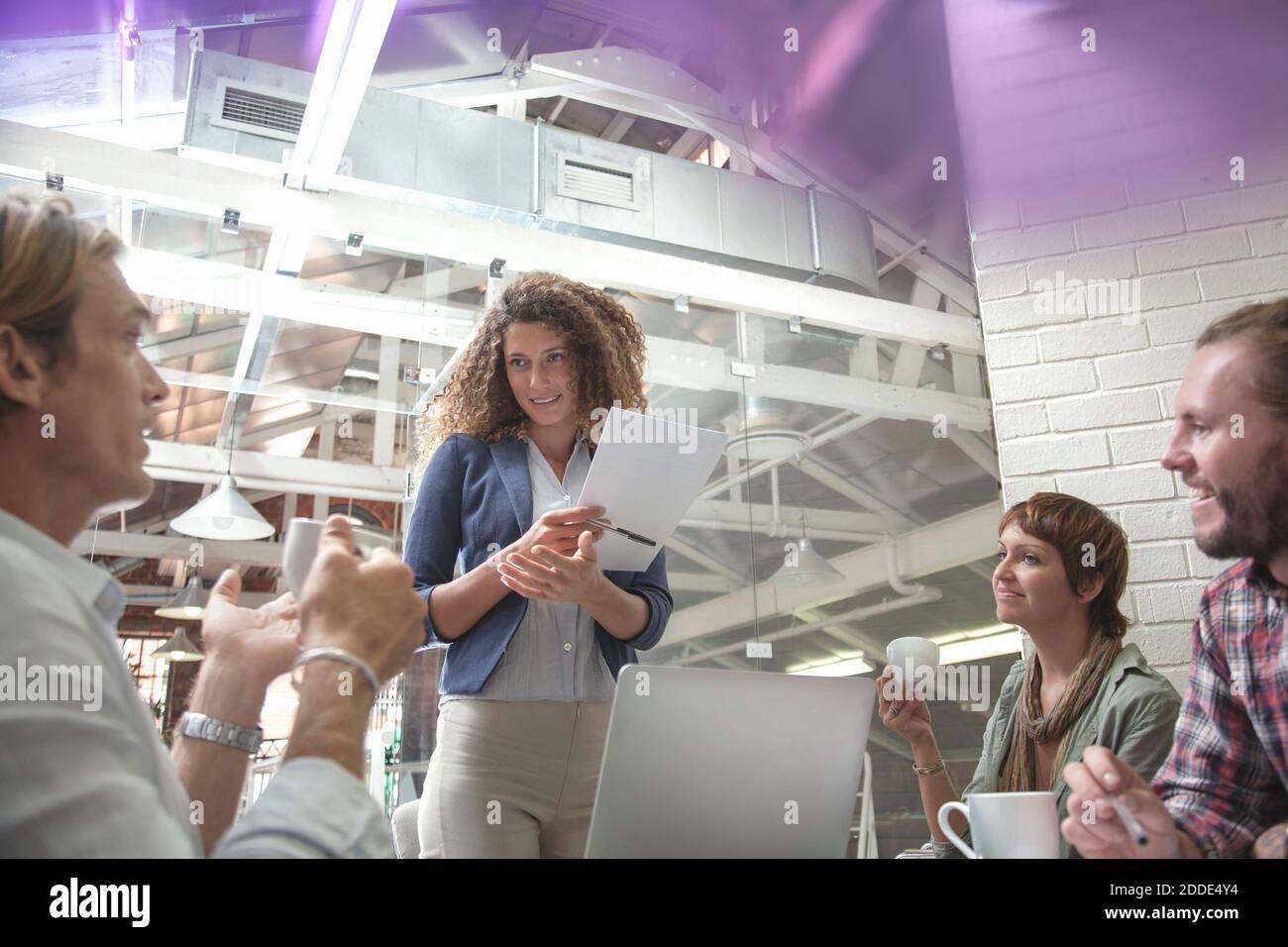 Team drinking coffee while working at office Stock Photo - Alamy