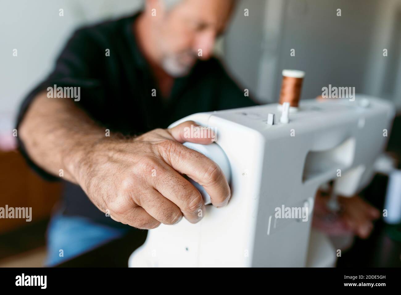Tailor adjusting sewing machine while working in studio Stock Photo - Alamy