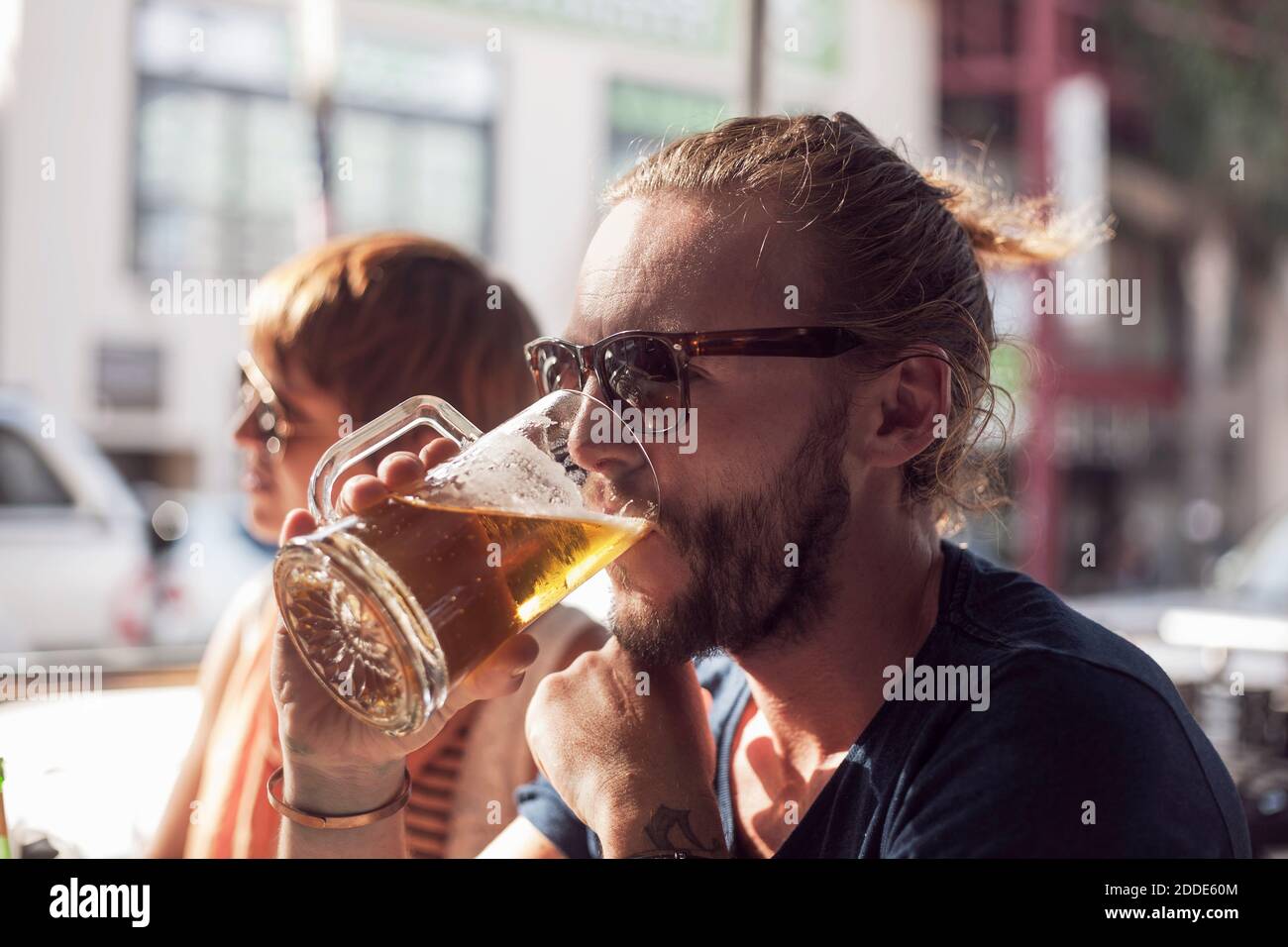 Mid adult man drinking beer while sitting in cafe Stock Photo - Alamy