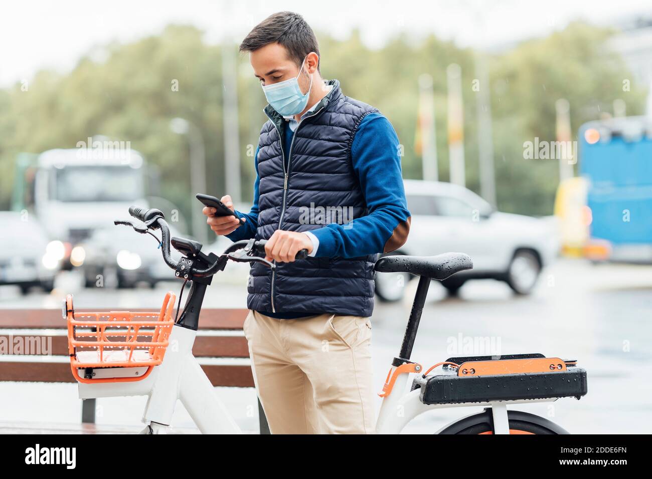 Young man using mobile phone while standing on street in city during ...