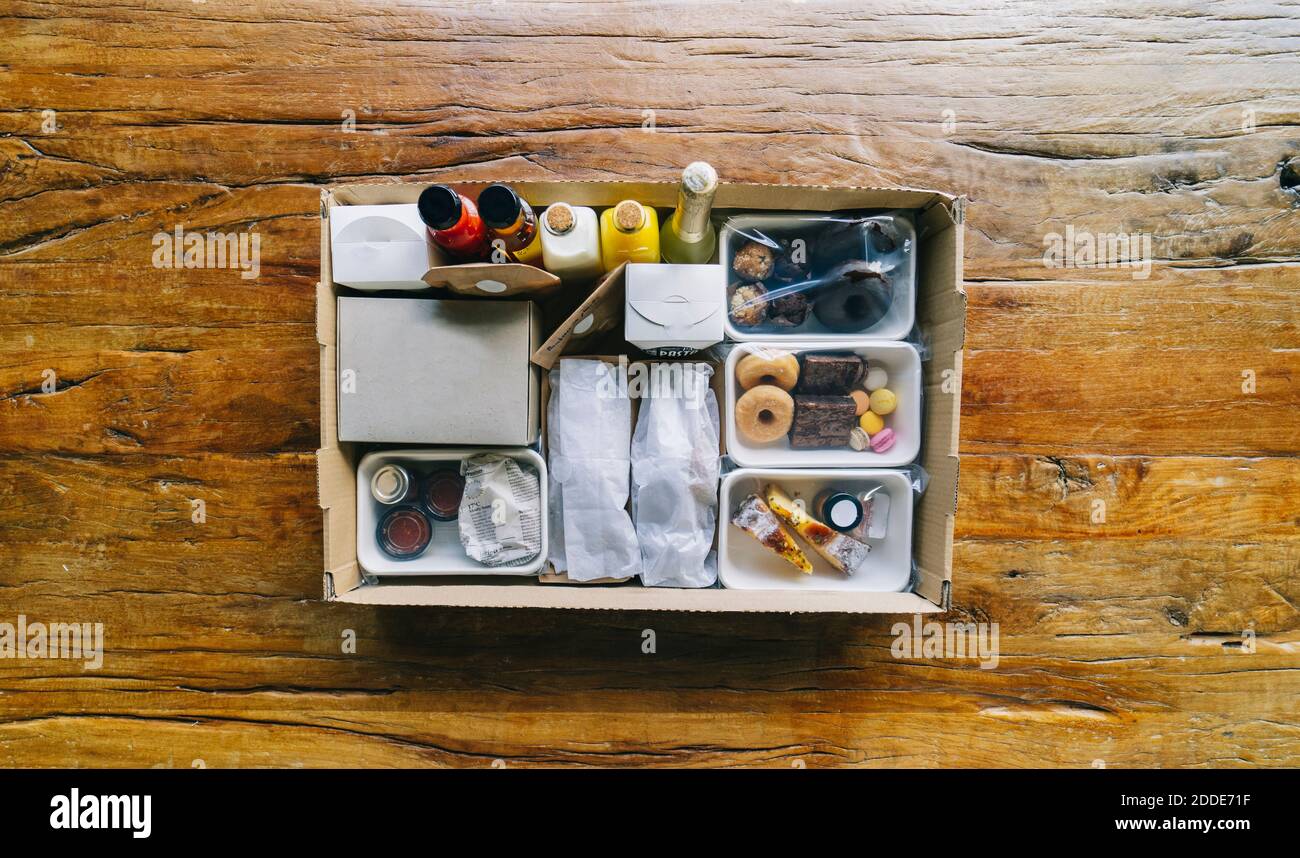 Food packages arranged in cardboard box on wooden table at restaurant ...