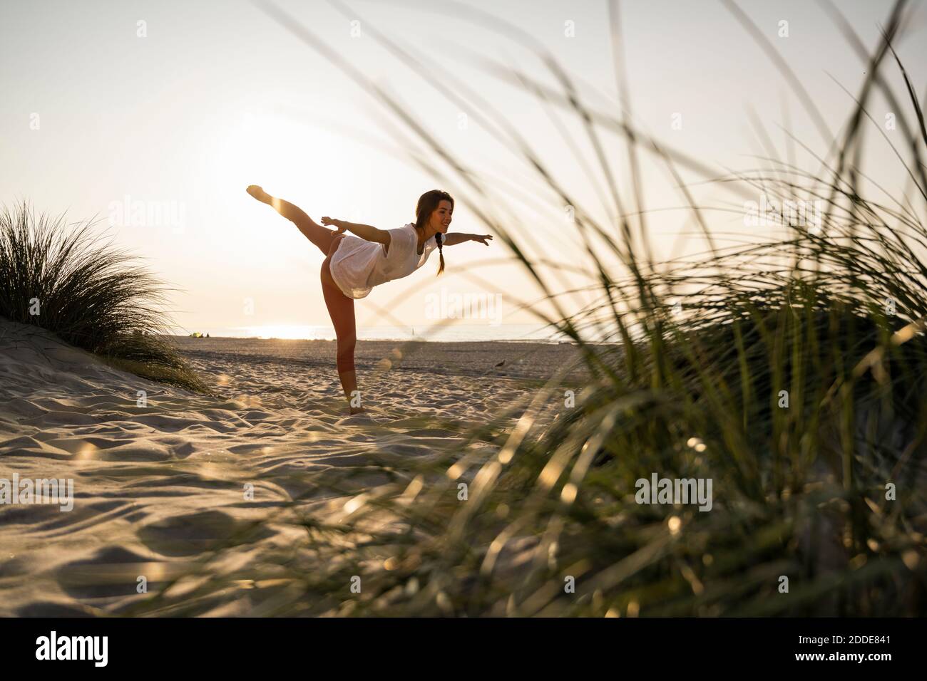 Young woman beach yoga hi-res stock photography and images - Alamy