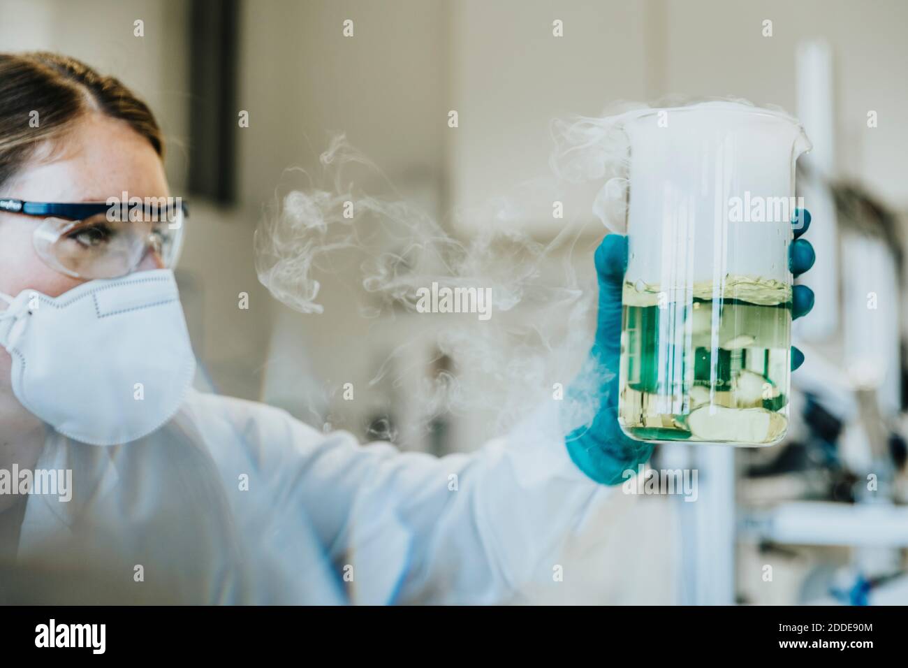 Laboratory assistant wearing protective face mask and eyeglasses ...