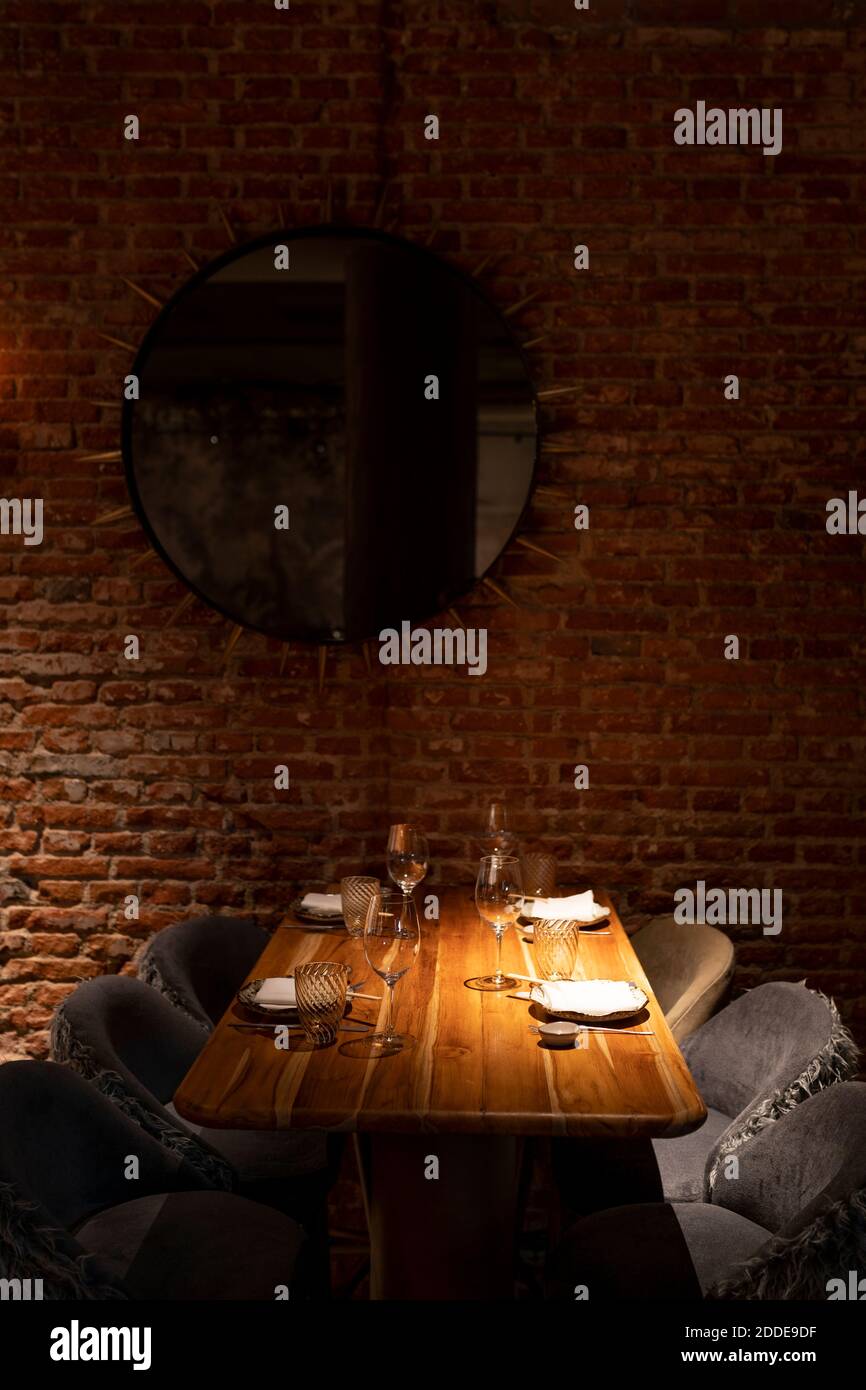 Place setting on table by brick wall in restaurant Stock Photo - Alamy