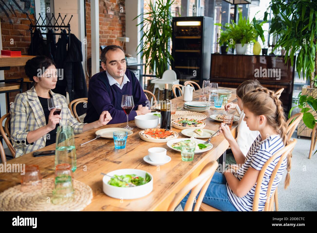 A young family with kids in a cafe, the parents are drinking wine Stock ...