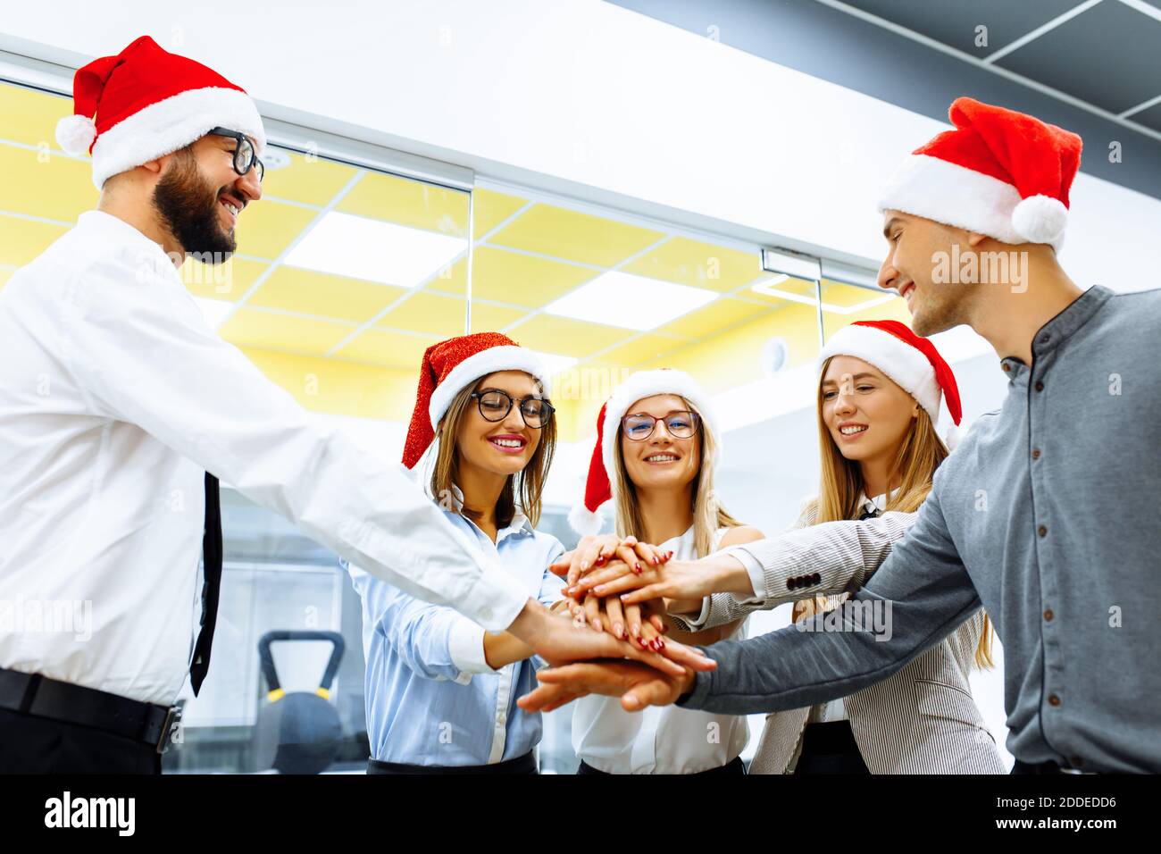 Happy big business team wearing Santa Claus hats demonstrating unity ...