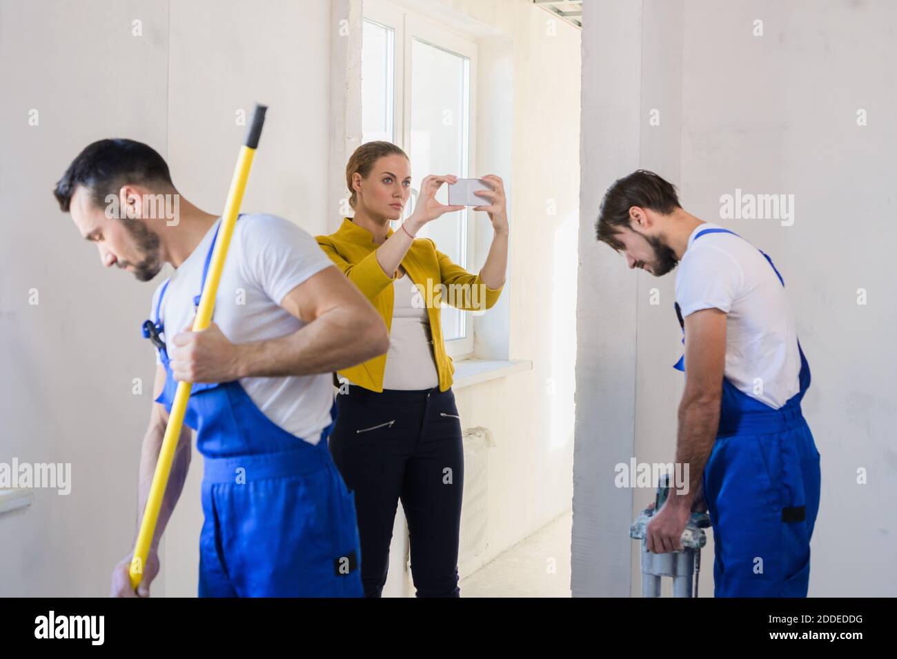 Construction team doing repairs. Two men use a roller and mixer Stock ...