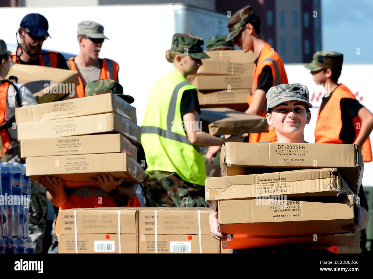 NO FILM, NO VIDEO, NO TV, NO DOCUMENTARY - Volunteers carry boxes of ...