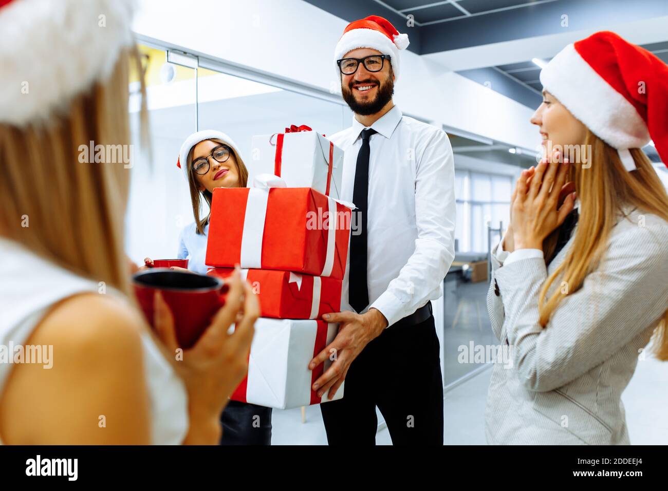 Work colleagues wearing santa claus hats hi-res stock photography and ...