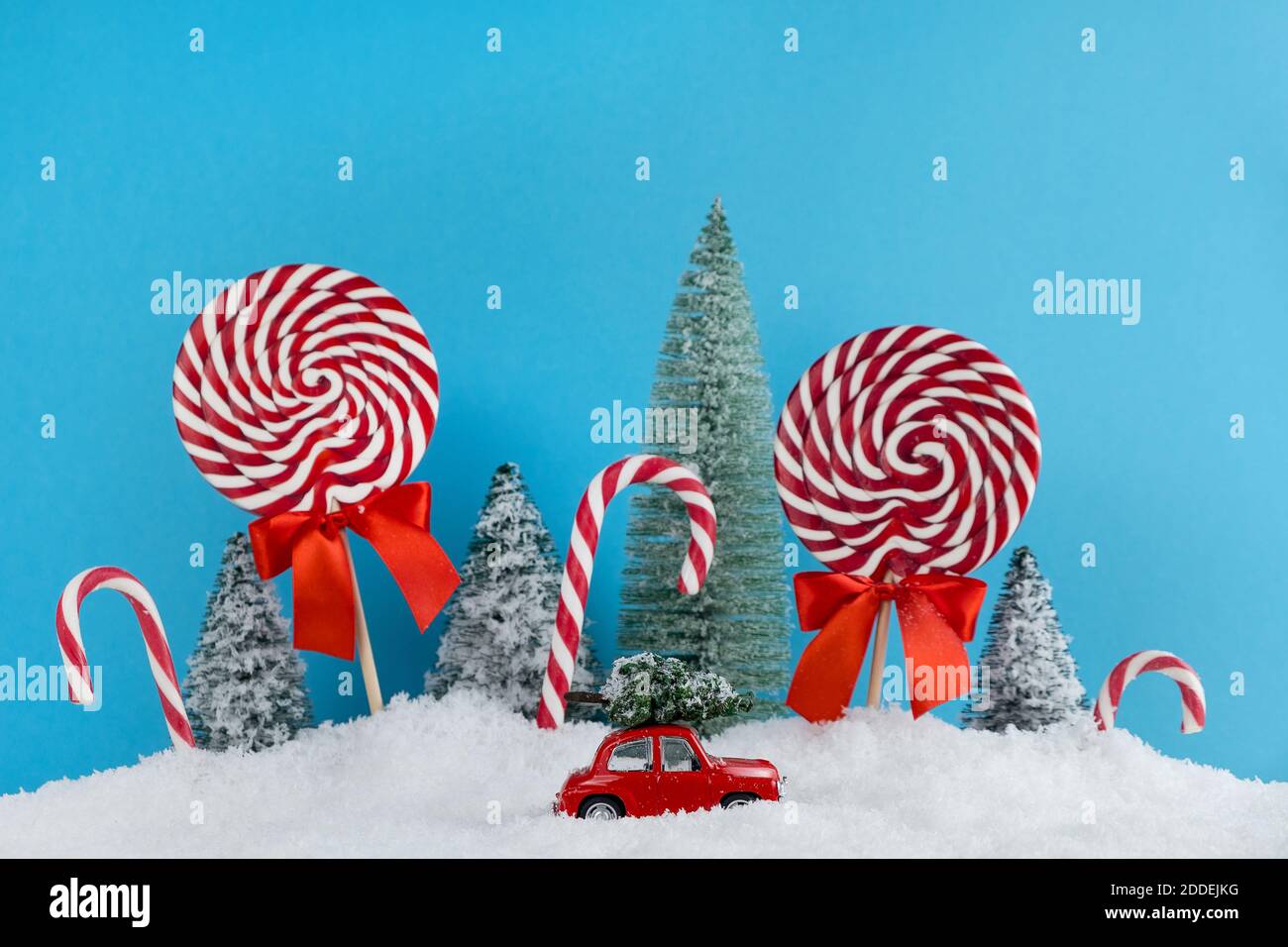 Red Santa car with Christmas tree in forest with candies and lollipops ...