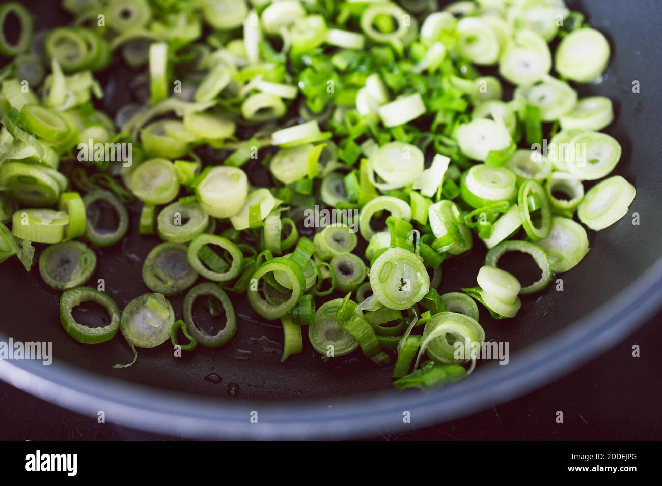 simple food ingredients concept, chopped spring onion getting sauteed ...