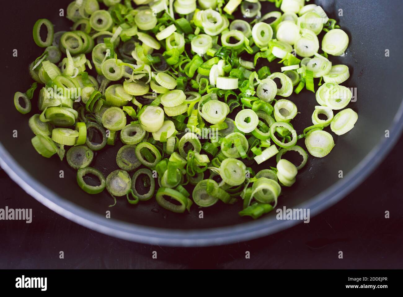 simple food ingredients concept, chopped spring onion getting sauteed ...
