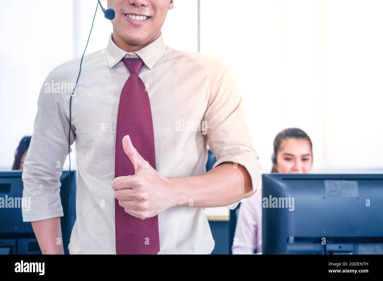 Young customer service men agent Thumbs up with headsets and computer ...