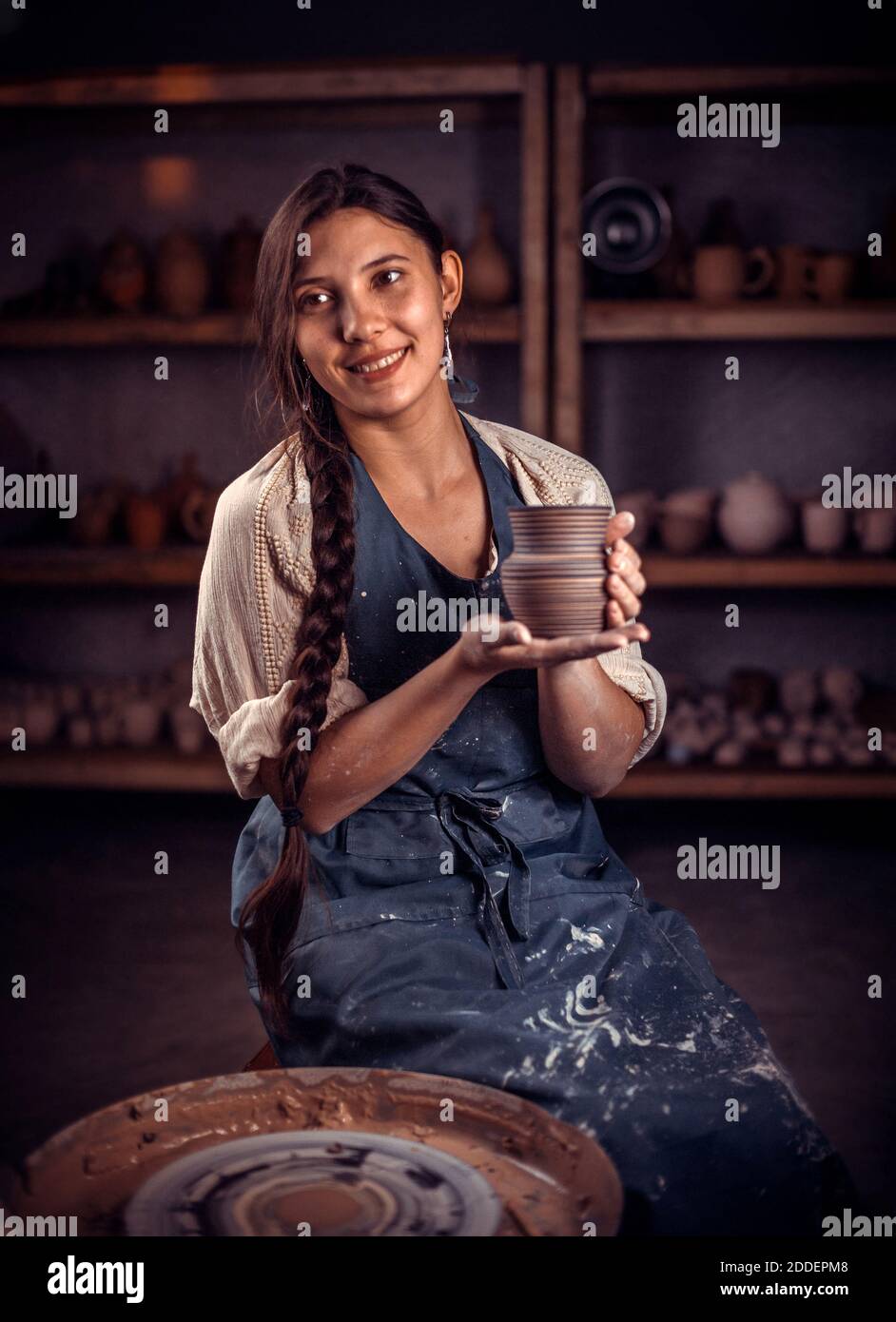 Pottery woman shows the finished clay product in workshop. Handmade ...