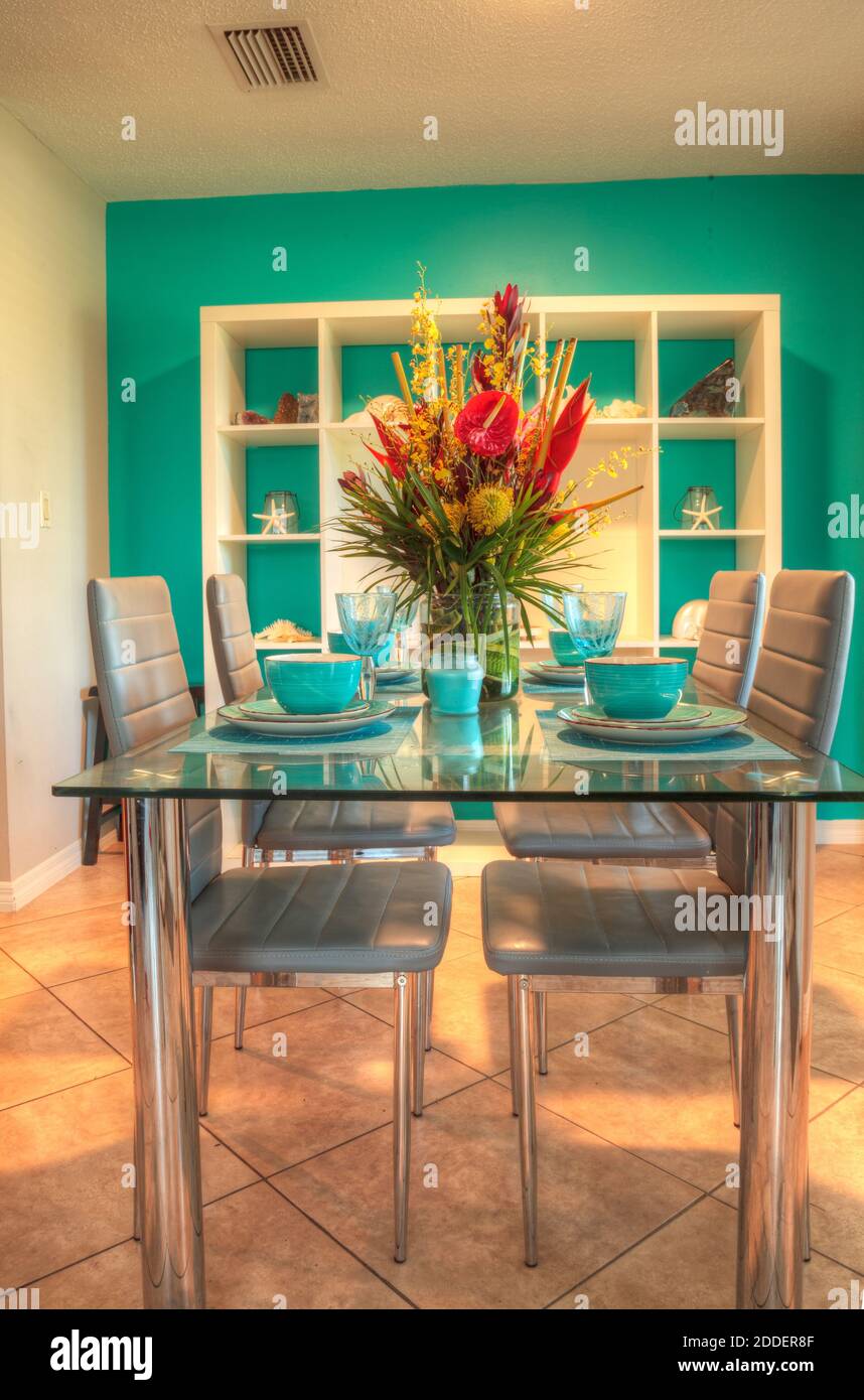 Tropical blue table set with flowers including Heliconia bihai, yellow ...