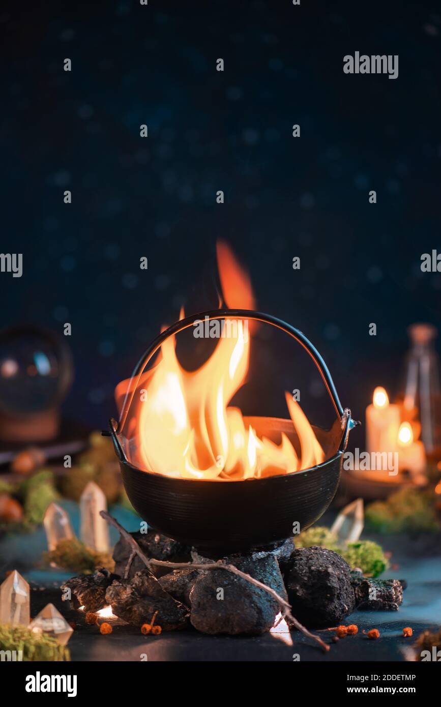 Burning magical potion, cauldron, crystals, and occult equipment ...