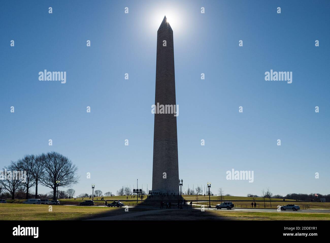 Washington Monument and sun casting a shadow on a clear blue sky day ...