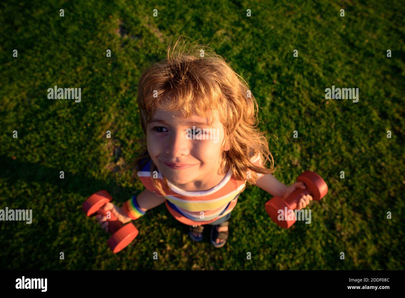 Funny child fitness and sport. Happy smiling kid with dumbbells. Wide ...