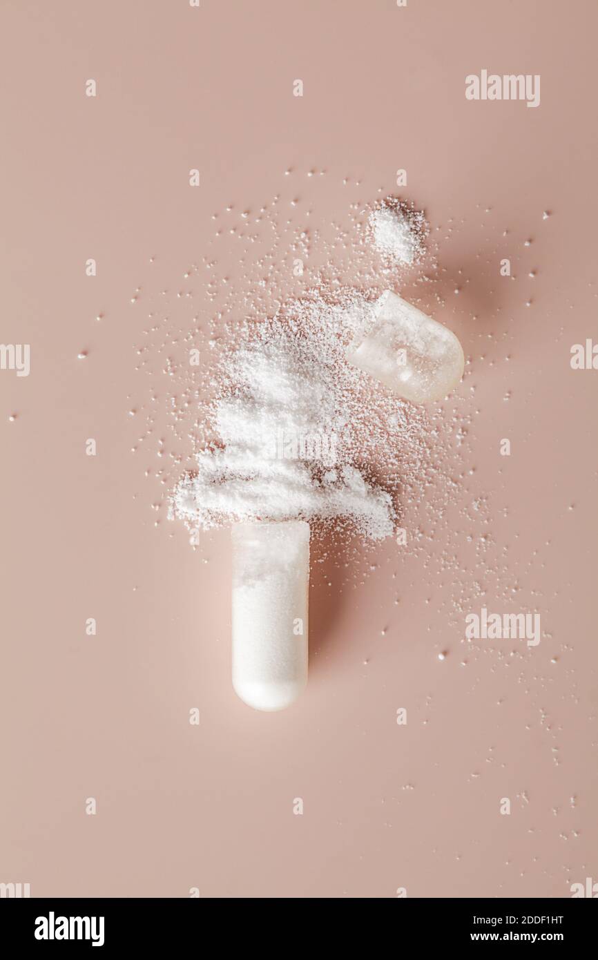 Health care concept. White medical open capsule with powder inside on ...