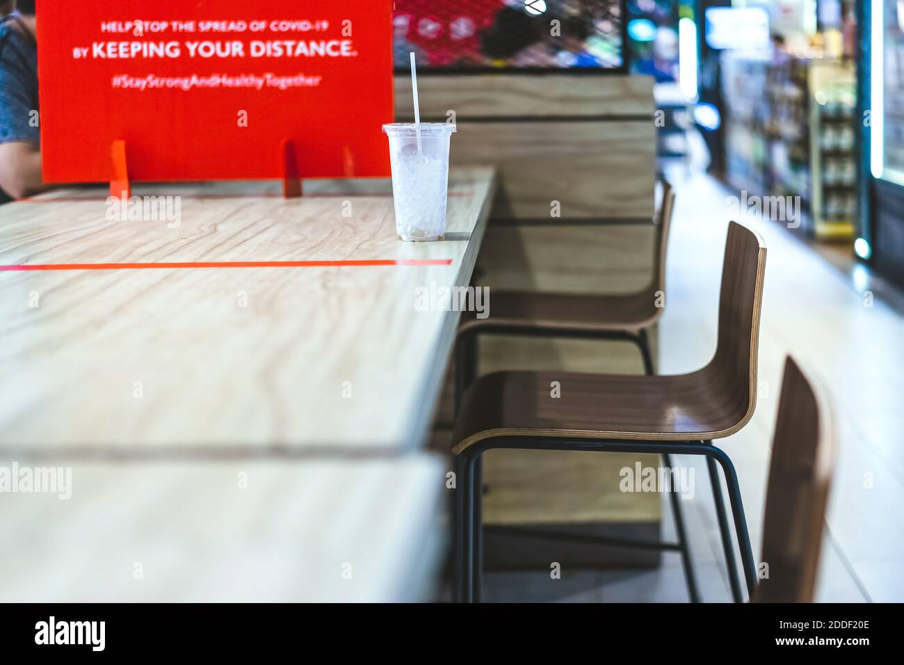 Plastic cup with ice on table with blurred image of protective ...