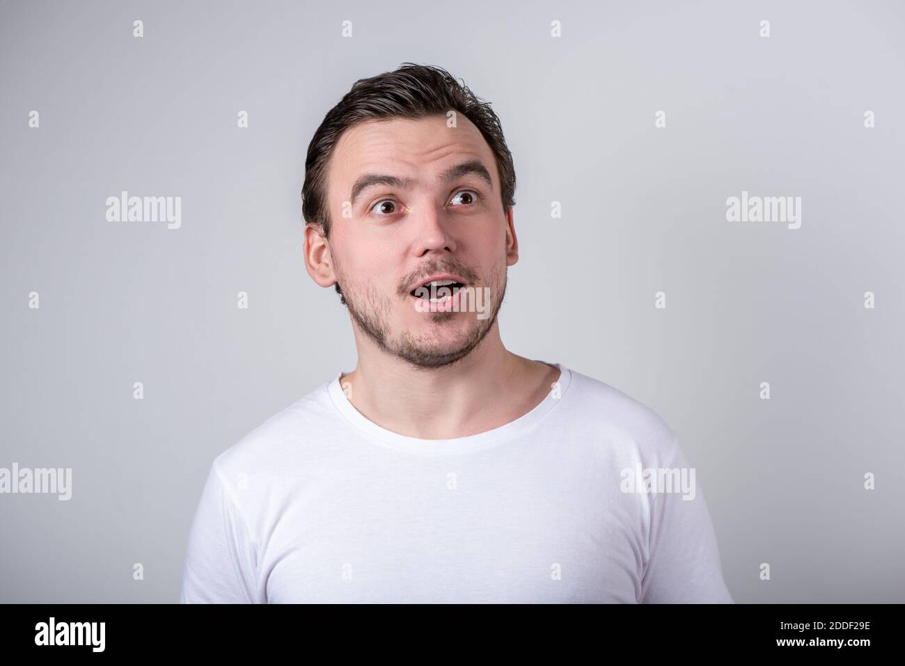 Handsome Brunette Guy With Bristles In A White T Shirt Makes Funny