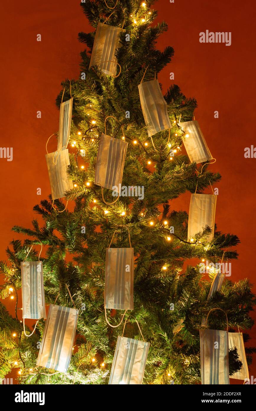 Christmas tree decorated with covid19 face masks on an orange ...