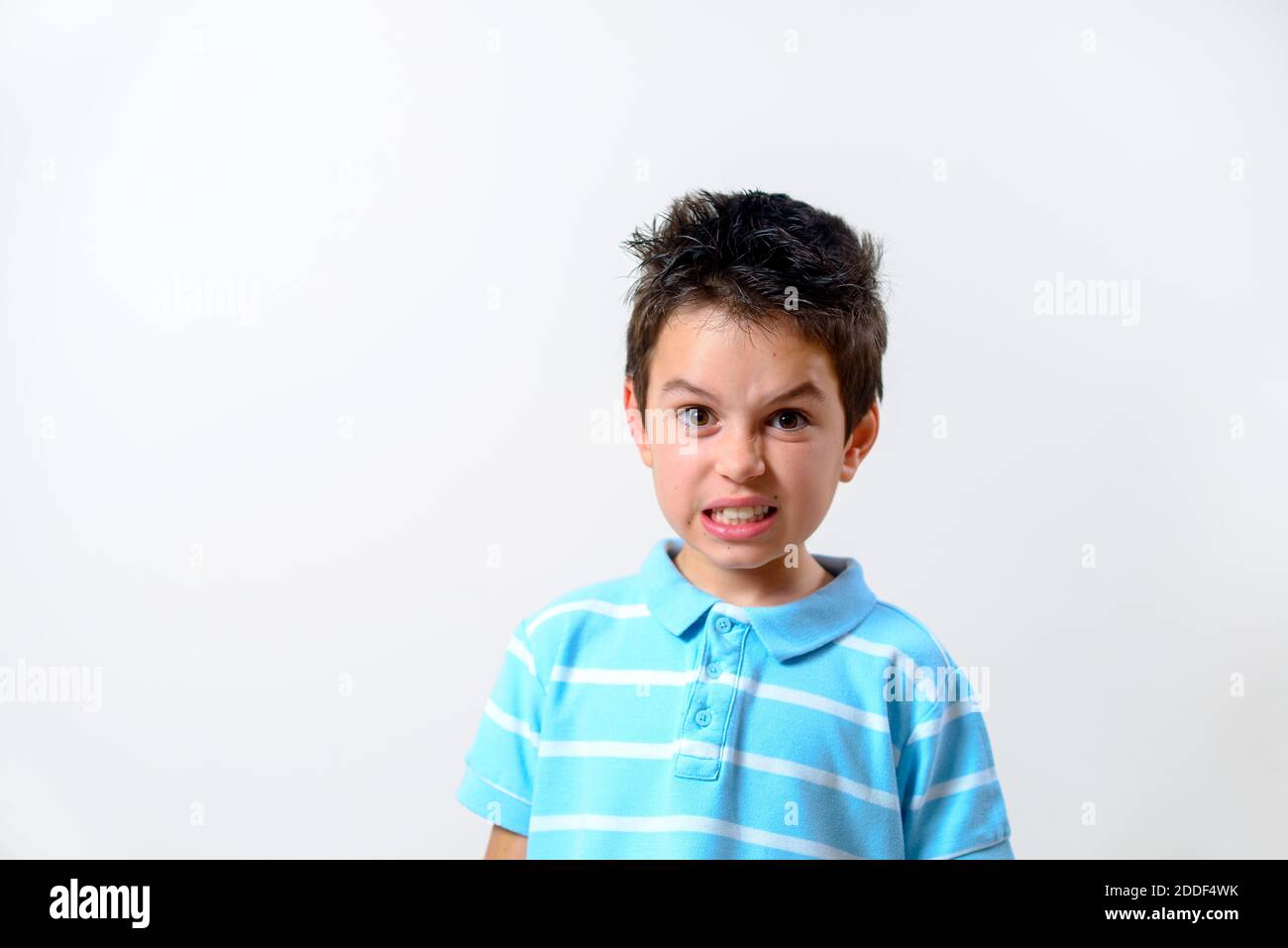 The boy in a blue T-shirt depicts a disgruntled grimace Stock Photo - Alamy