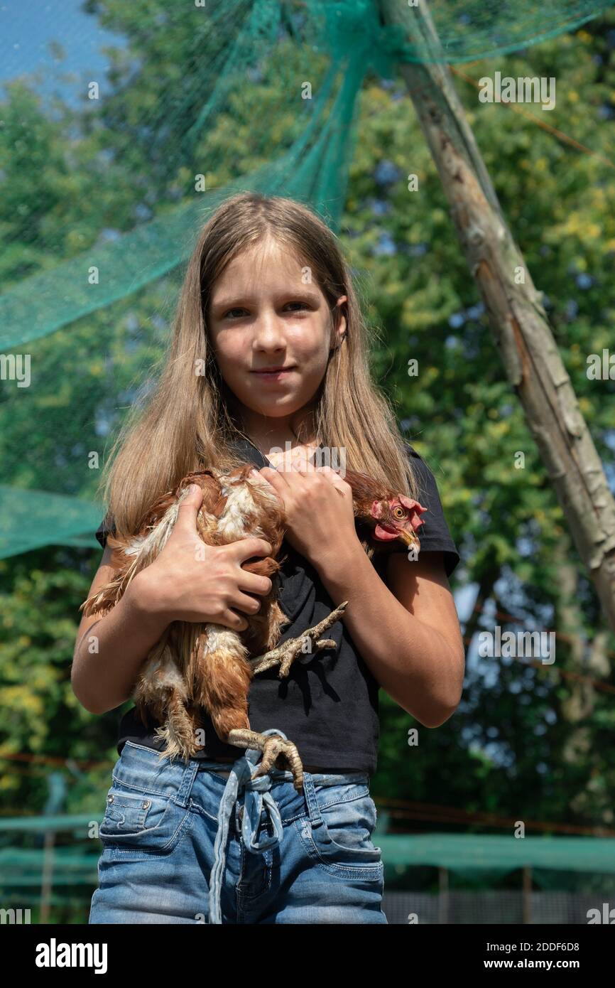 Beautiful girl with brown hen Stock Photo - Alamy