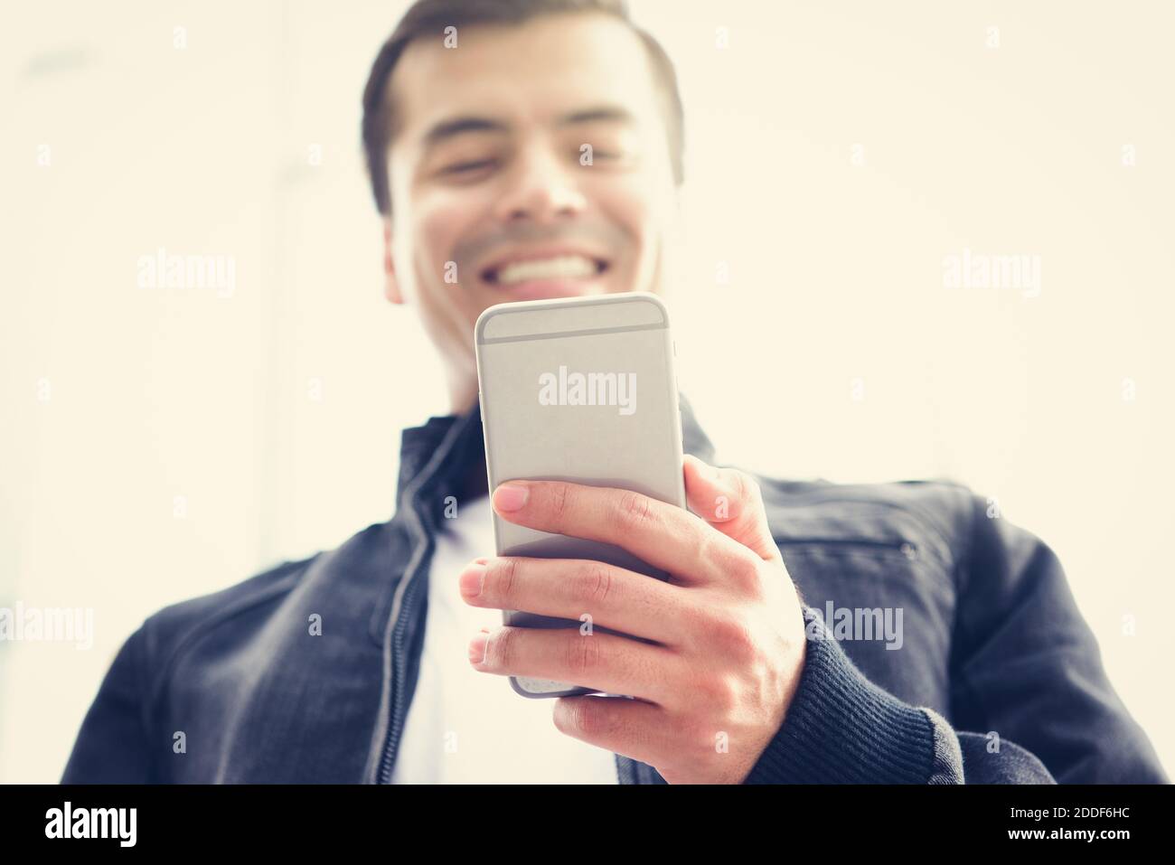 Young man using smarthone with smiling face, looking up angle Stock ...