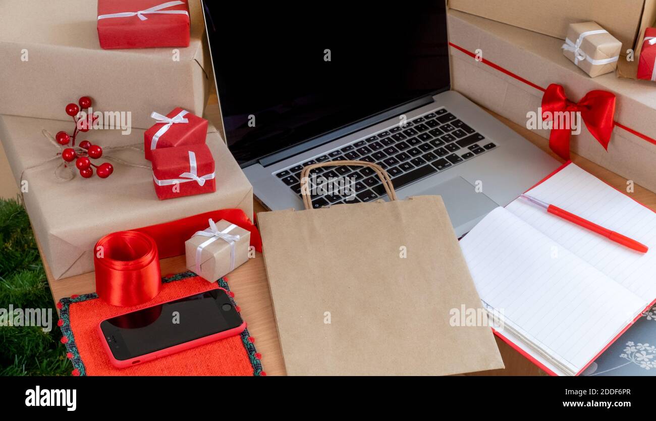 Laptop with gifts, Packing boxes and Shopping Bag on the work place ...