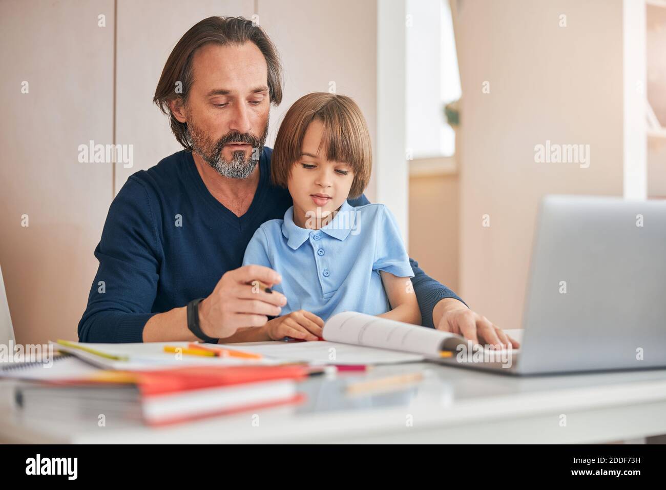 Caring father helping his child to cope with homework Stock Photo - Alamy