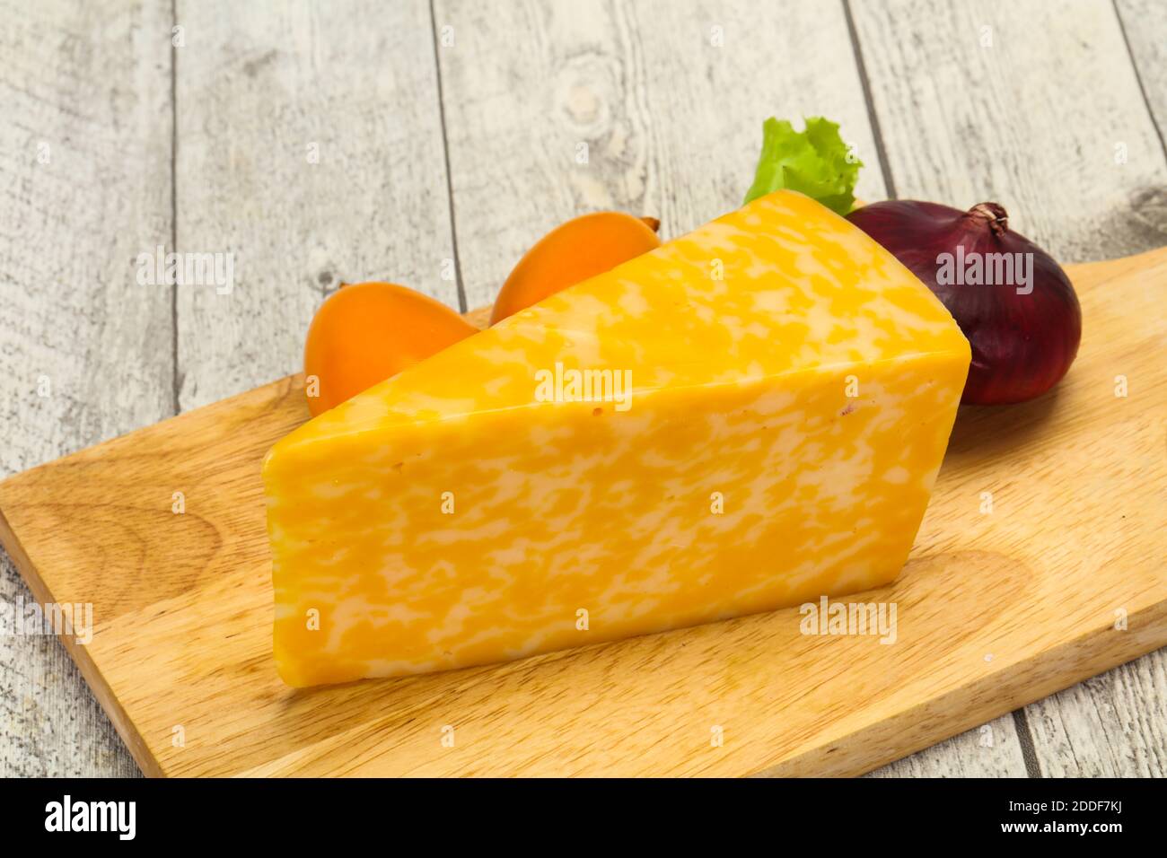 Marble cheese triangle over wooden background Stock Photo - Alamy