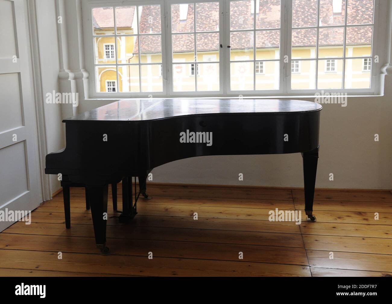 piano standing next to a window, a stringed musical instrument Stock ...