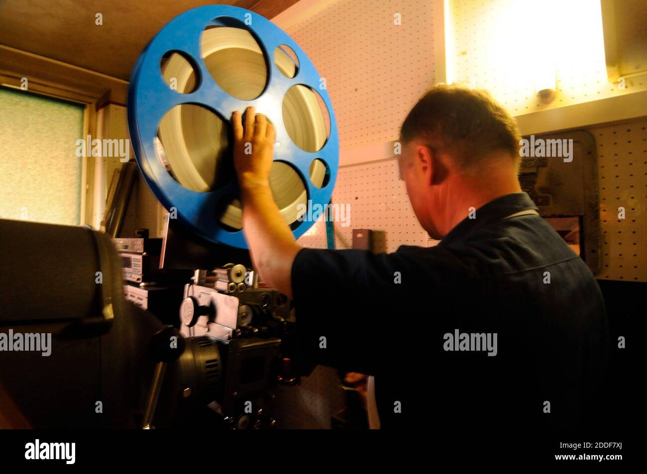 film projectionist in a cinema with film reel and projector Stock Photo ...