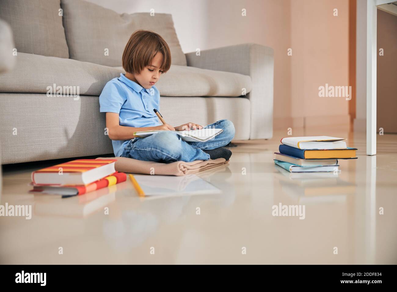 Calm child looking concentrated on doing home tasks Stock Photo - Alamy