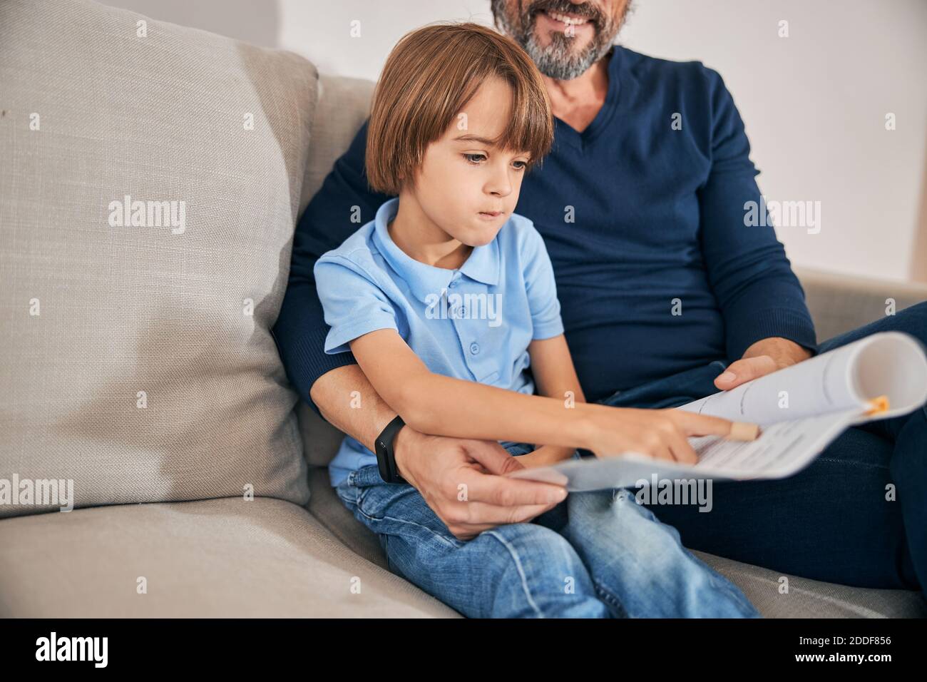 Kid looking concentrated on the process of reading Stock Photo - Alamy